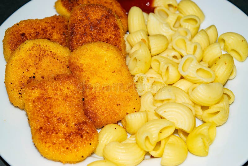Fried Chicken Nuggets and Cooked Pasta on a Plate. Close Up Stock Photo ...
