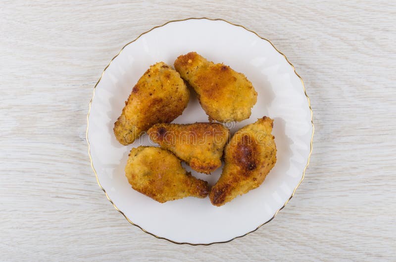 Fried Chicken Winglets in Breading in Plate on Wooden Table Stock Photo ...
