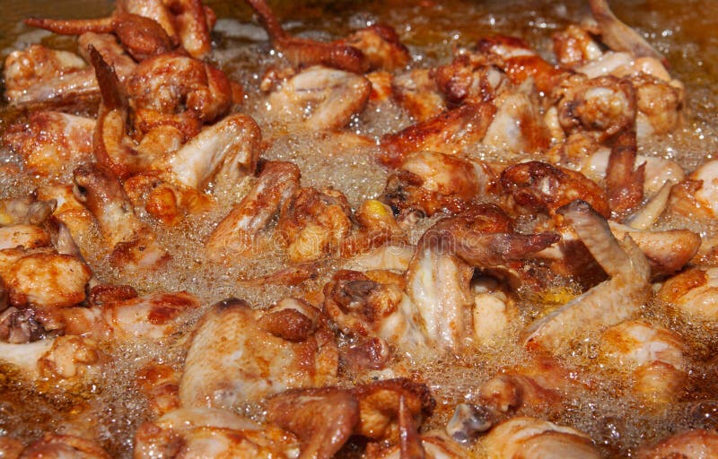 Fried Chicken Wings in Oil , in a Large Pot, Bubbles in the Oil Cooking ...