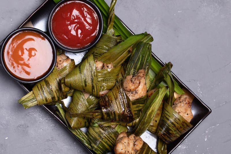 Fried Chicken Wrapped in Pandan Leaves in a Black Plate Stock Image ...