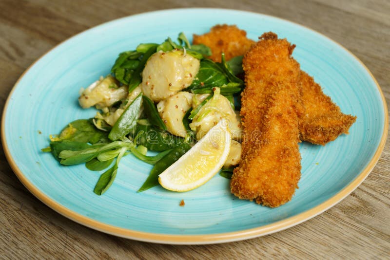 Fried Cod Fish Fillet with Potato Salad, Dijon Mustard and a Slice of ...