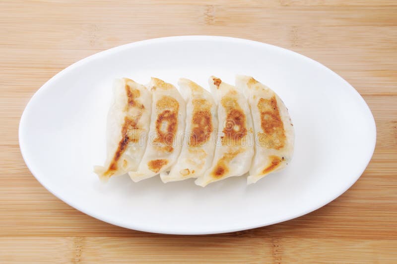 Fried Dumpling Gyoza. Garnished on Plate on Table Cloth Stock Photo ...