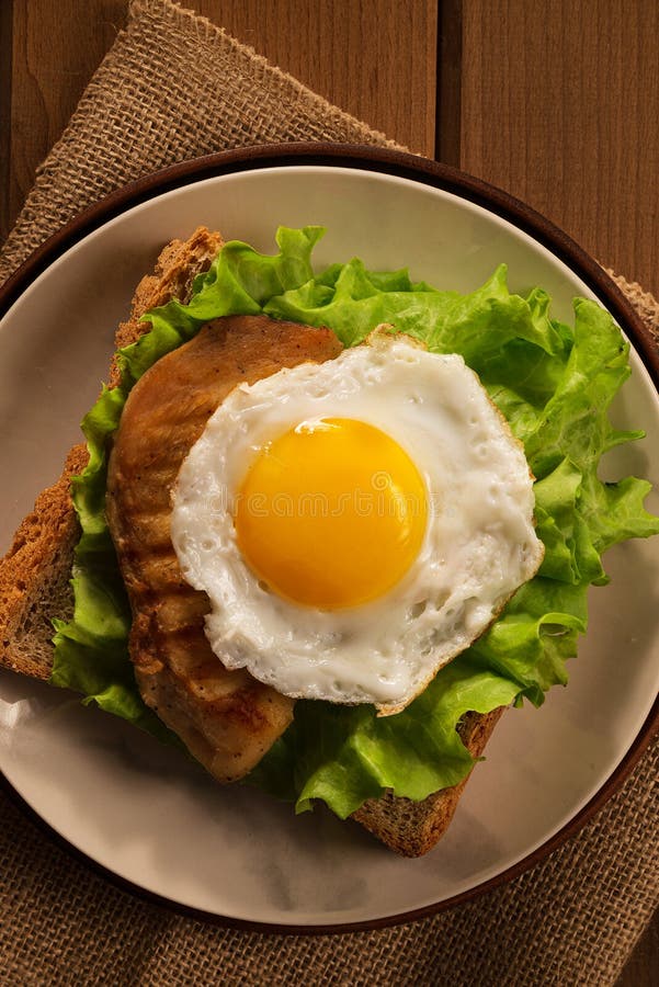 Fried Egg and Chicken on Bread for Breakfast on Plate and Rustic Table ...