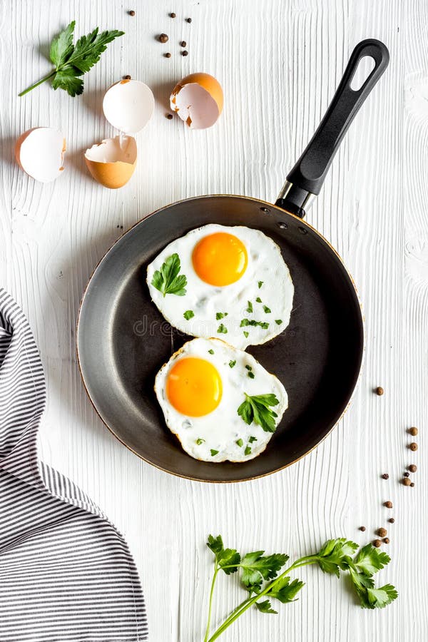 Fried Eggs on Frying Pan on White Table Top-down Stock Image - Image of ...