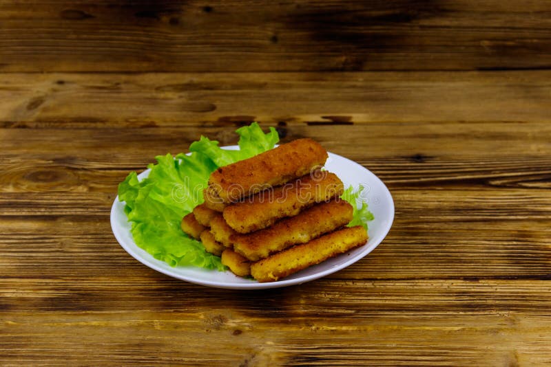 Fried Fish Fingers on a Plate with Lettuce on Wooden Table Stock Image ...