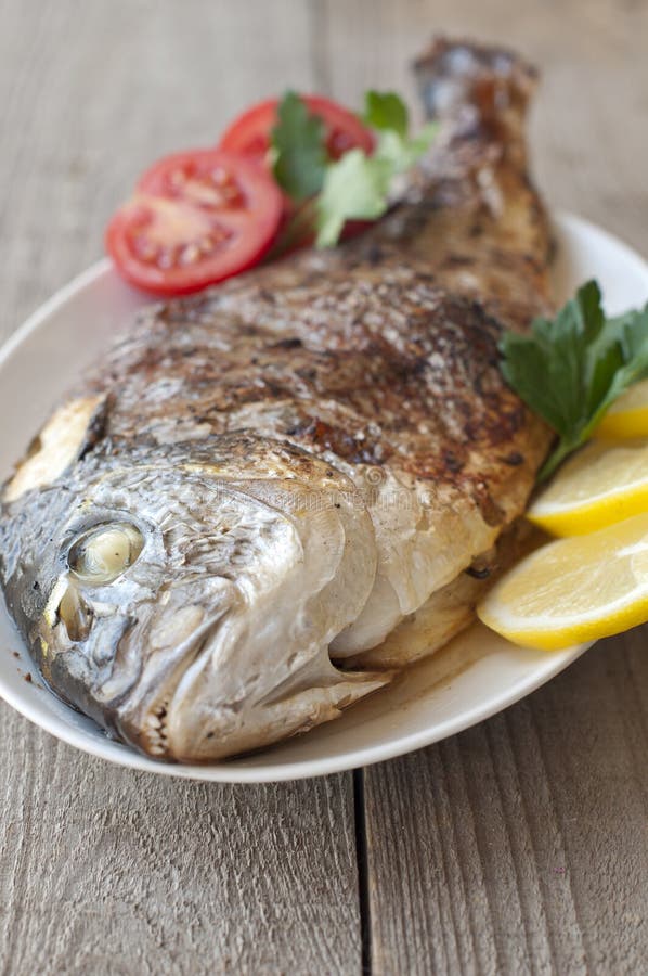 Fried Fish Garnished with Lemon, Tomato Stock Photo - Image of parsley ...