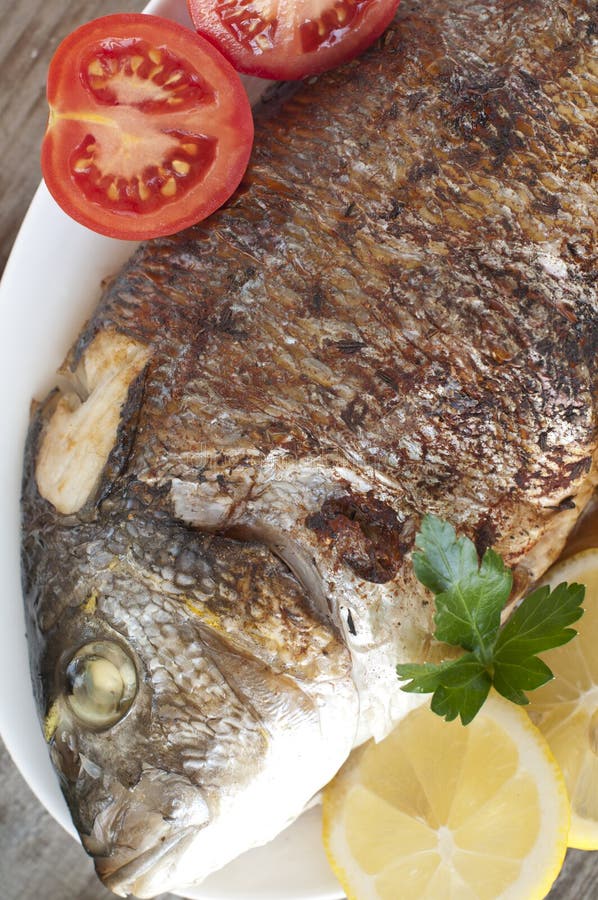 Fried Fish Garnished with Lemon, Tomato Stock Image - Image of meal ...