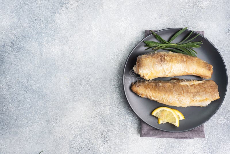 Fried Fish Hake Pollock and Slices of Fresh Lemon. Grey Concrete ...
