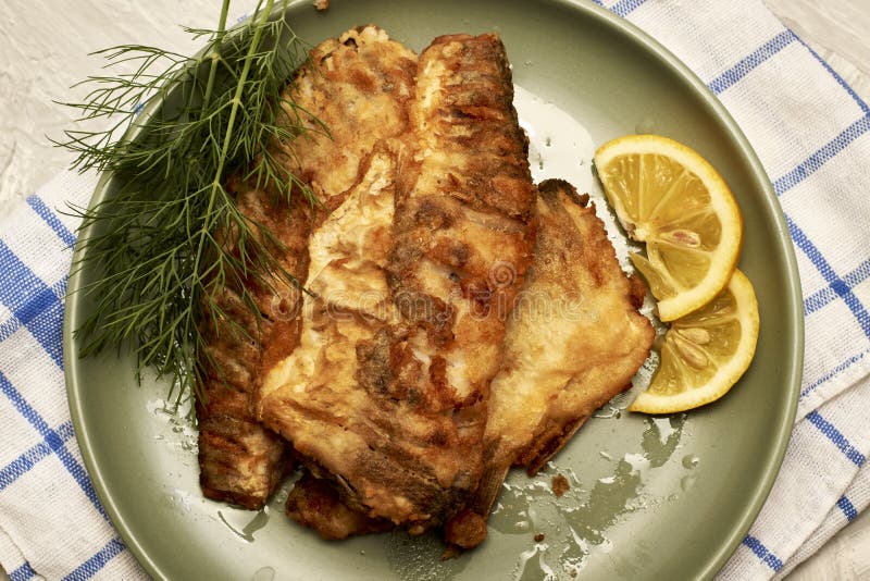 Fried Fish with Lemon and Herbs on a Plate on the Table Top View Stock ...