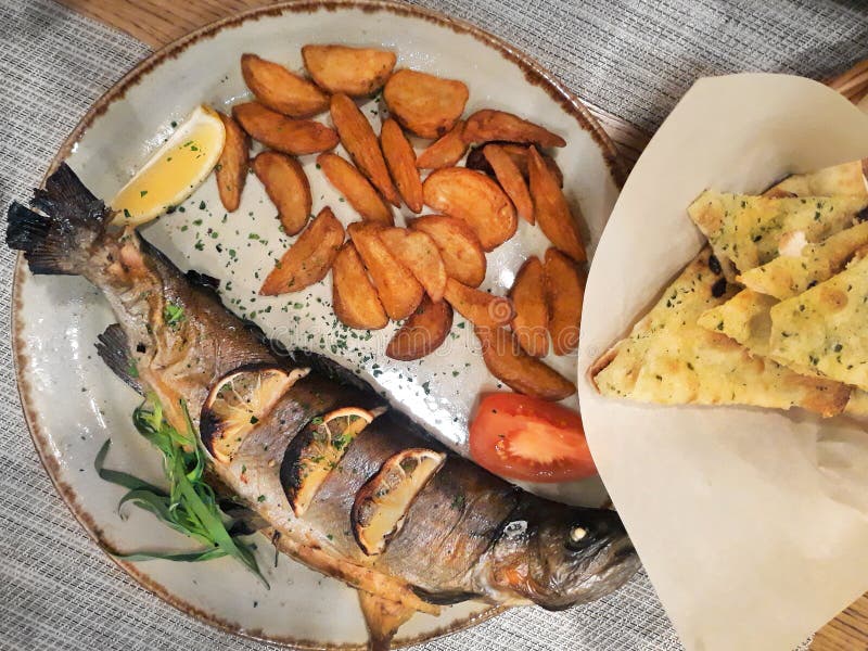 Fried fish with potatoes stock image. Image of dish - 217688001