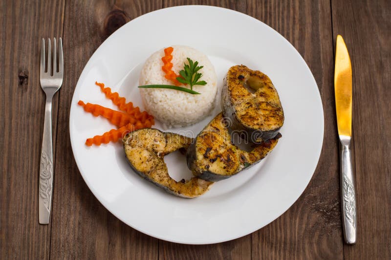 Fried Fish Steak with Boiled Rice and Carrots. Top View. Close-up Stock ...