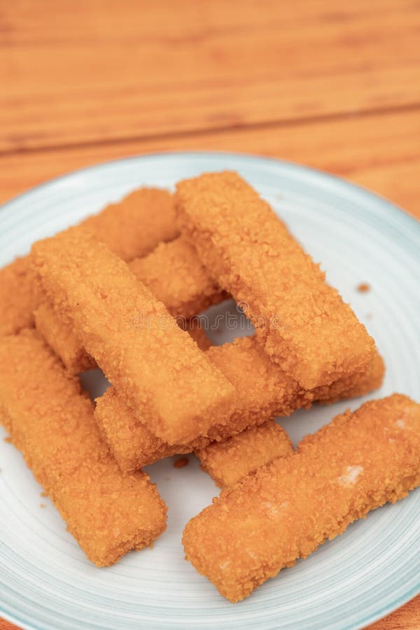 Fried Fish Sticks on the Plate Above Wooden Background Stock Photo ...