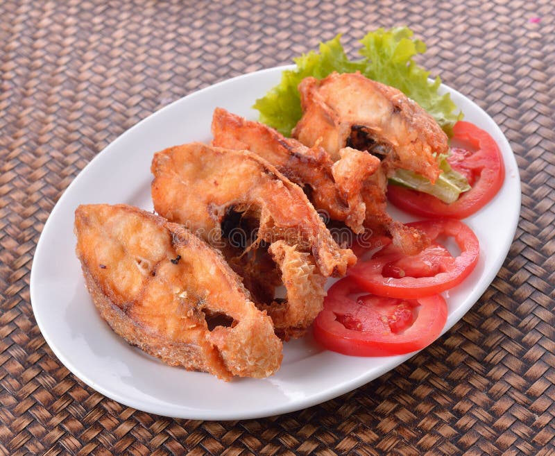 Fried fish on white plate stock photo. Image of crispy - 175298862