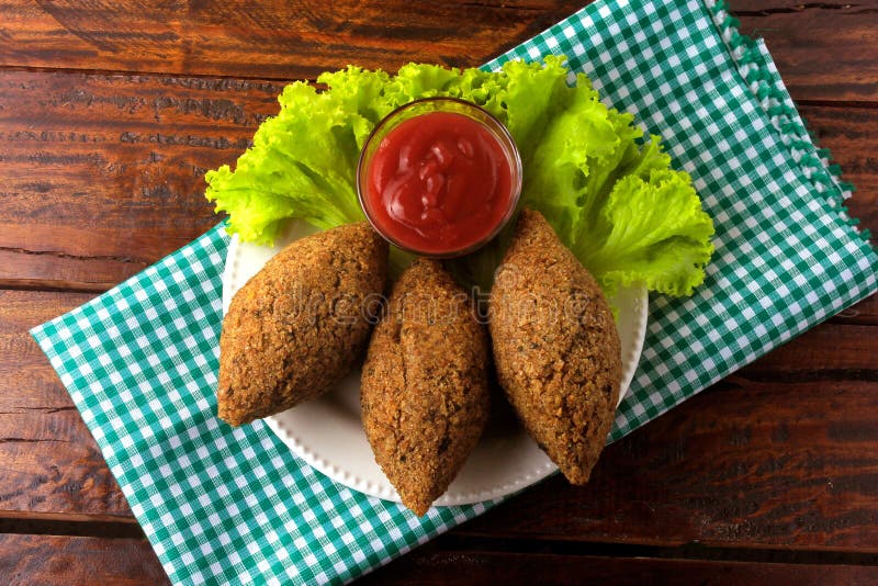 Fried Kibbeh with Tomato Sauce on a Plate, Over Rustic Wooden Table ...