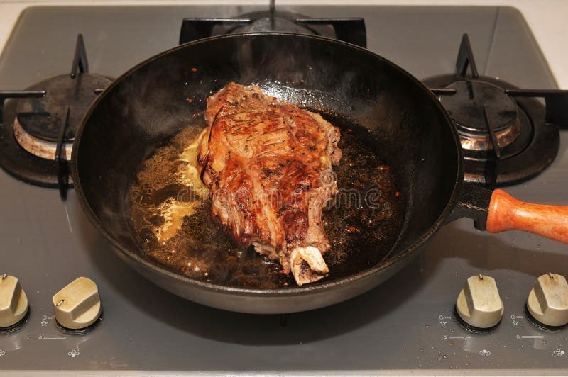 Fried meat on frying pan stock photo. Image of cook, iron - 41901316
