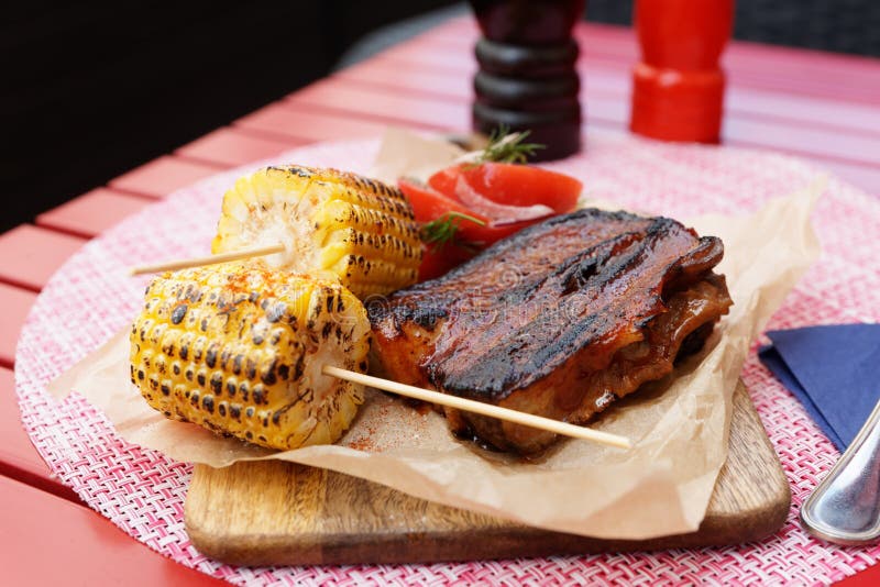 Fried Pork Ribs with Grilled Corn on Red Table Stock Image - Image of ...