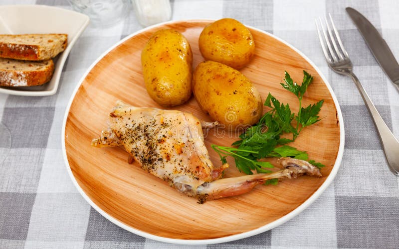 Fried Rabbit Leg with Jacket Potatoes on a Ceramic Plate Served on a ...
