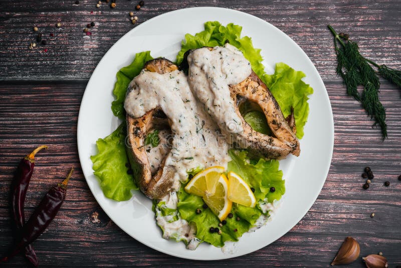Fried Red Fish in Cream Sauce with Lemon and Lettuce in White Plate ...