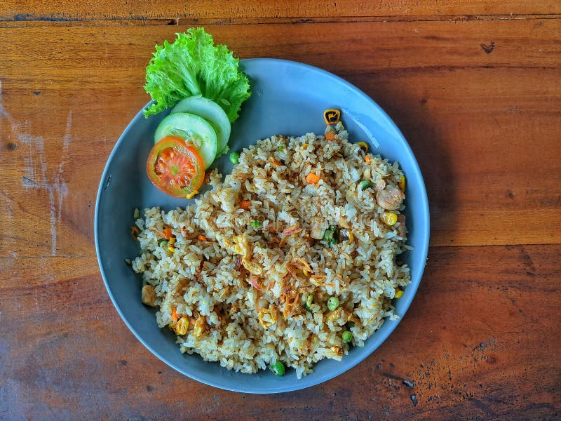 Fried Rice Served on a Plate Complete with Sliced Tomatoes, Cucumbers ...