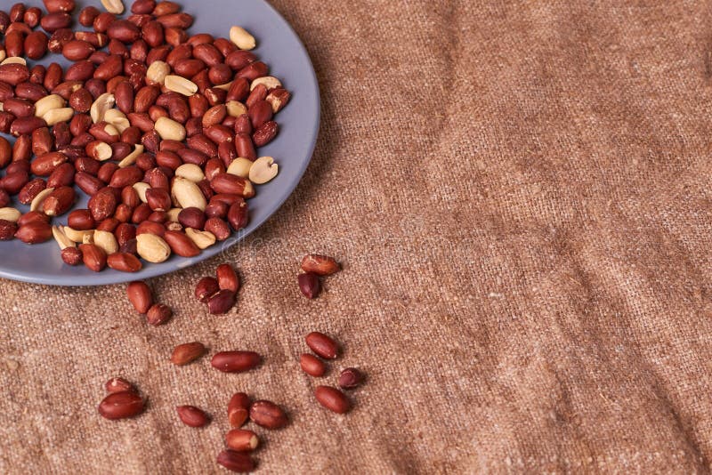 Fried Roasted Peanut Seed on Blue Plate on Sackcloth Background. Space ...