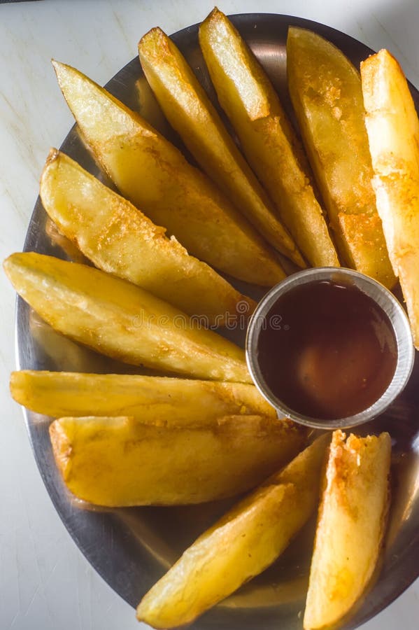 Fried Rustic Potato on a Metal Plate with a Red Sauce in the Middle ...
