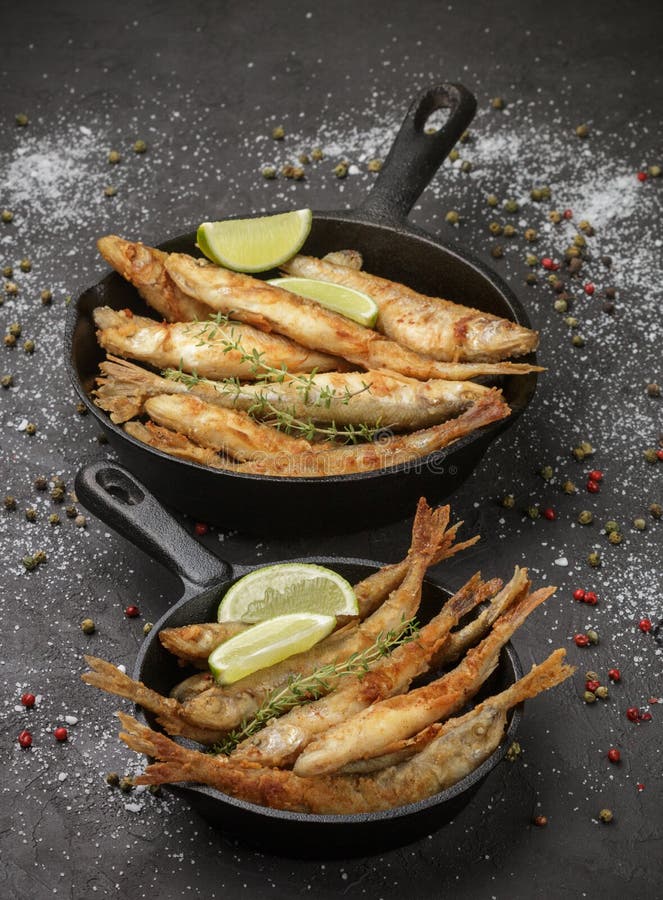 Fried Smelt in a Frying Pan on the Table with Spices, Lime and Thyme ...