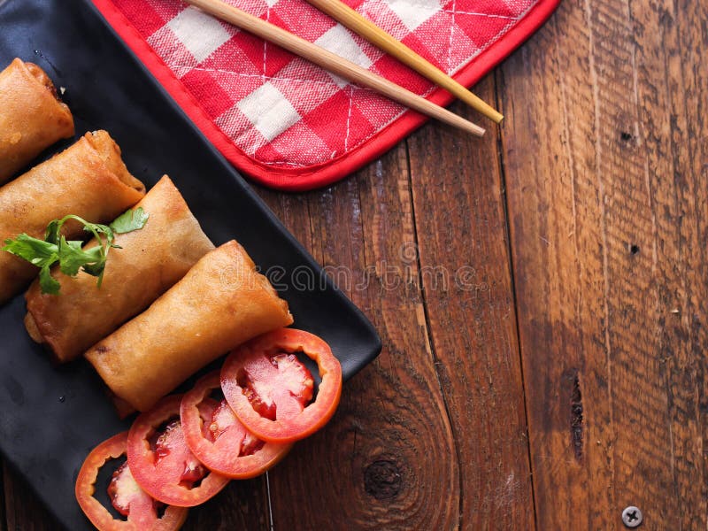 Fried Spring Rolls Served in a Black Square Plate with Sliced Tomatoes ...