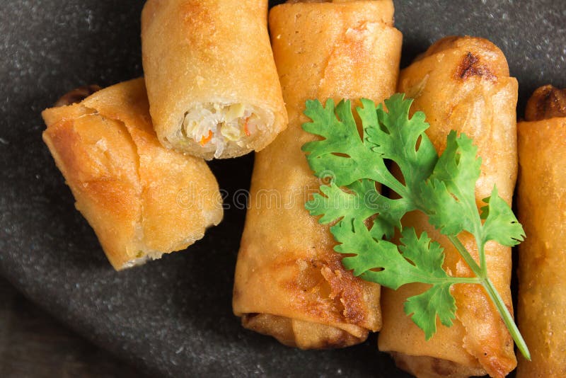 Fried Spring Rolls Stacked on Black Slate Plate on Wooden Stock Image ...