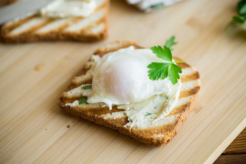 Fried Toast Bread with Spread and Poached Egg, on a Wooden Table. Stock ...