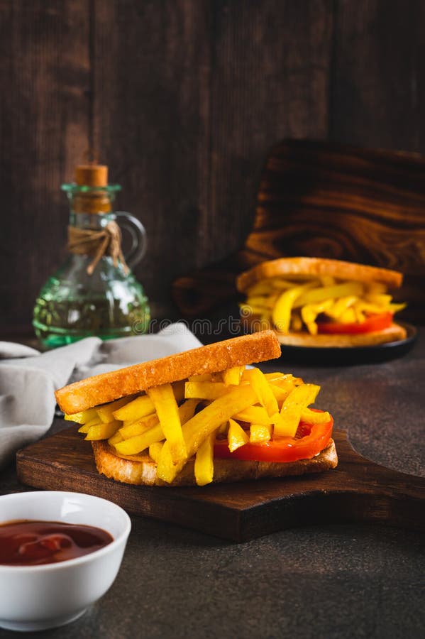Fried Toasts with French Fries and Tomato on a Board on the Table ...