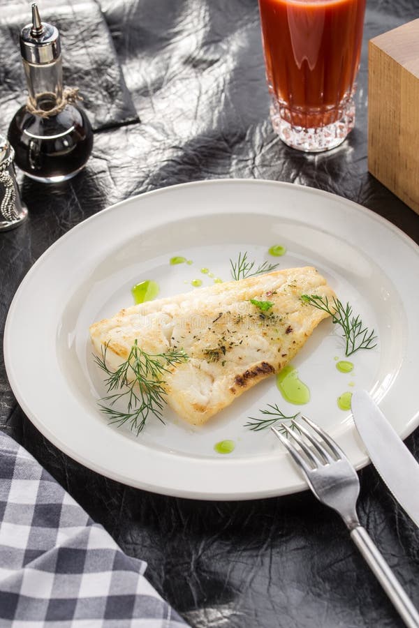 Fried White Fish Fillet on White Plate with Tomato Juice on Black ...