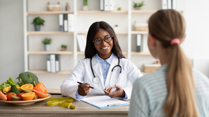 Friendly African American Female Nutritionist Giving Consultation To