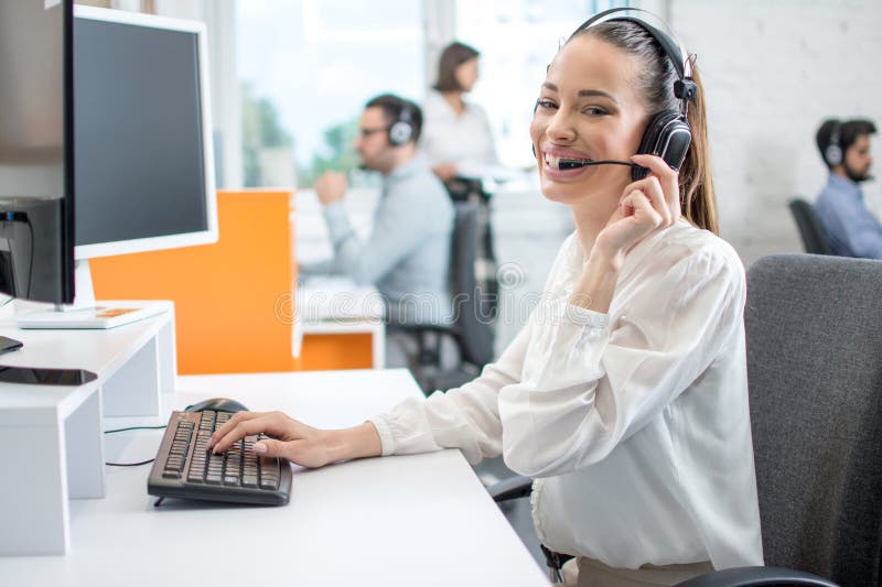 Friendly Call Center Operator Lady in Wireless Headset Talking with ...