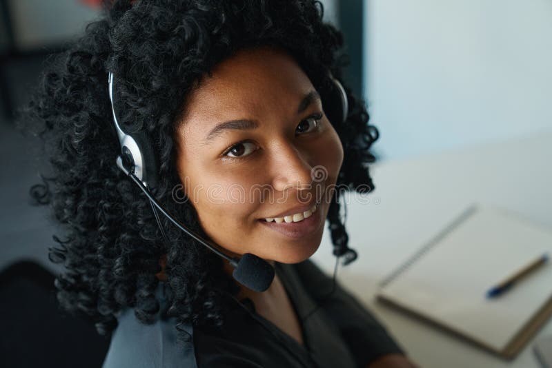 Friendly Call Center Operator with Mobile Headset Sitting at Table ...