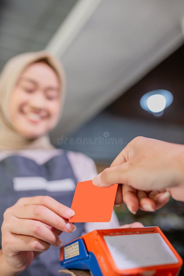 A Friendly Cashier is Helping a Customer with Their Payment in a Retail ...