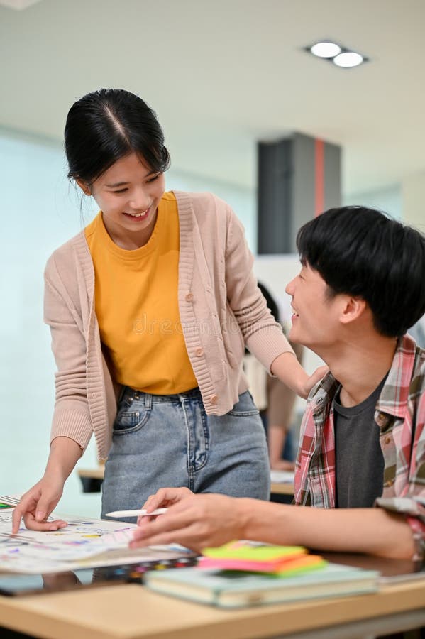 A Friendly Asian Female Graphic Designer is Talking and Working with a ...