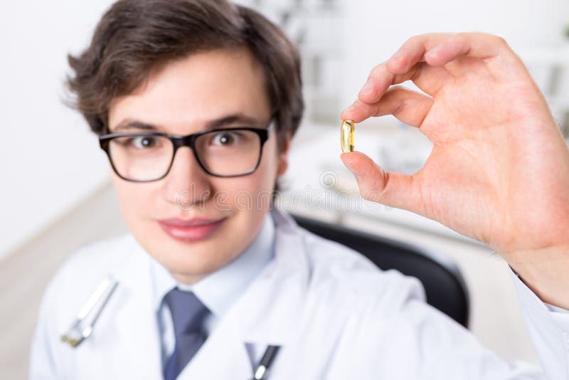 Friendly Doctor Holding Pill Stock Photo - Image of european, handsome ...