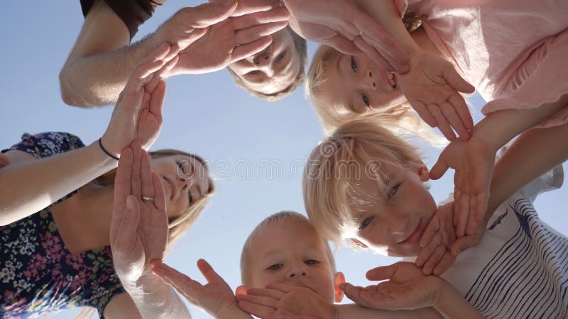 A Friendly Family Makes a Circle Out of Their Hands and Looks into it ...