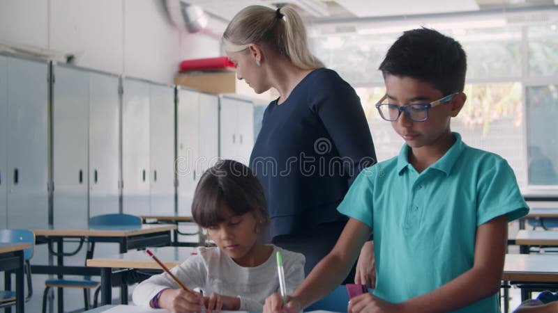 Friendly Female School Teacher Watching Pupils Stock Video - Video of ...