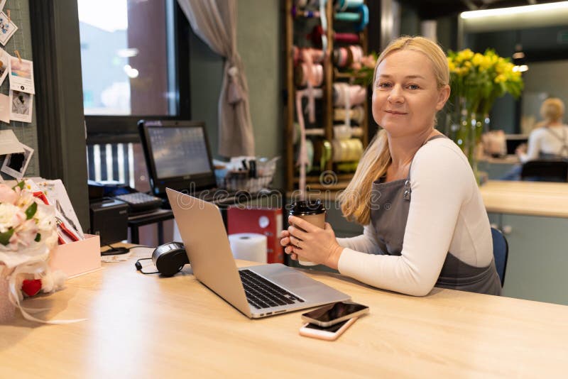 Friendly Flower Shop Owner Working at the Computer with a Smile on Her ...