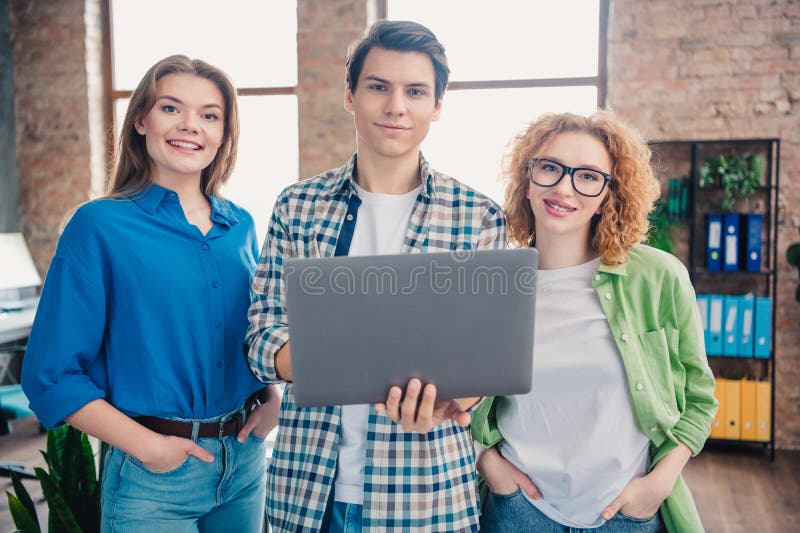 Friendly Group of Young Professionals Collaborating with a Laptop in a ...