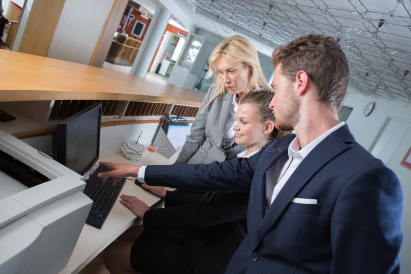 Friendly Hotel Workers at Reception Desk Stock Photo - Image of female ...