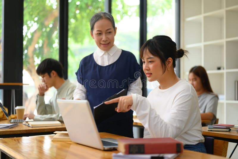 Friendly Senior Professor Helping Female Student with Assignment Stock ...