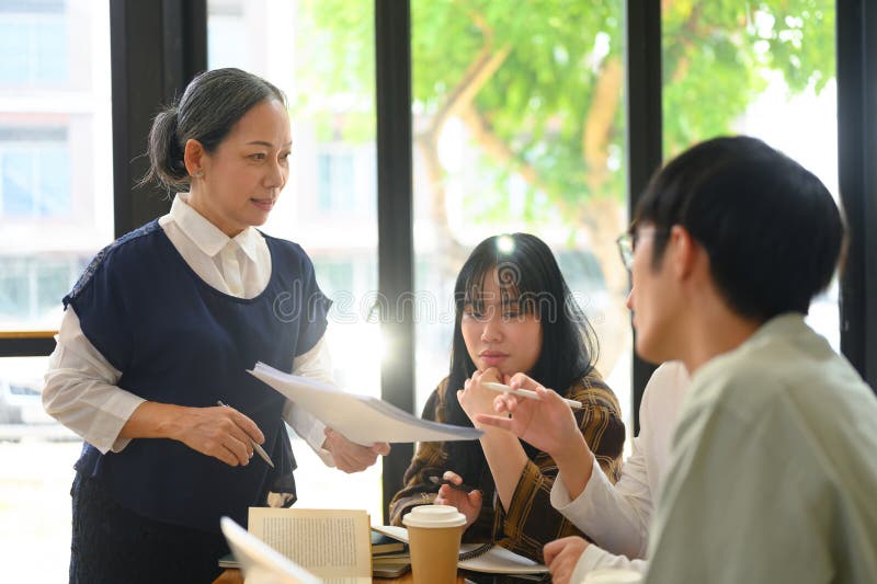 Friendly Senior Professor Helping Group of Students during Class at ...