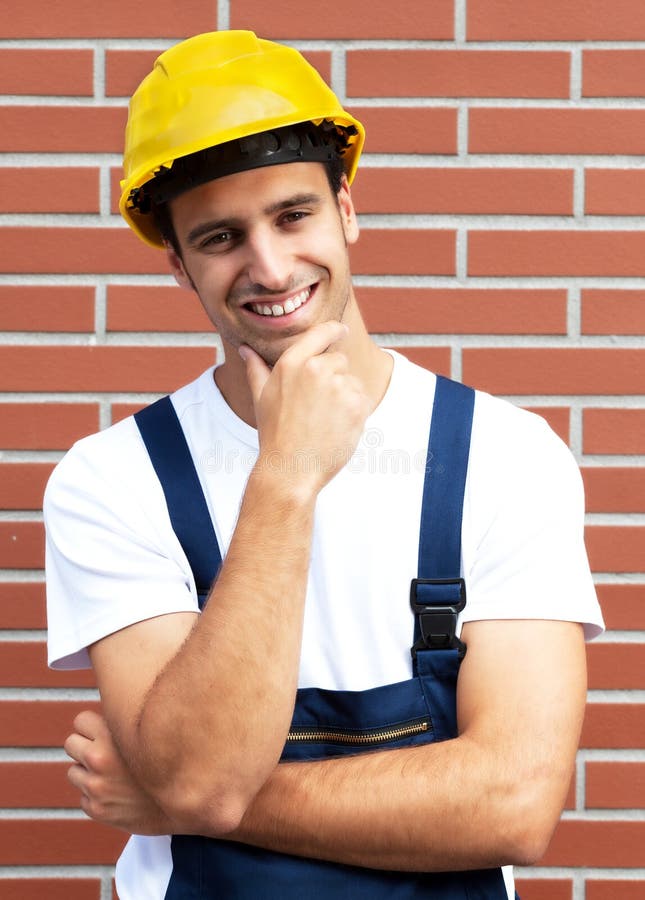 Friendly Smiling Worker in Front of a Brick Wall Stock Photo - Image of ...