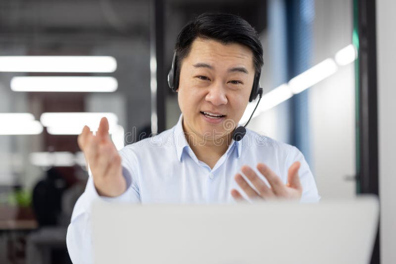 Friendly Support Manager in Wireless Headphones Looking at Computer ...