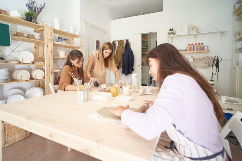 Friends with Aprons in a Pottery Workshop Preparing Clay To Create ...
