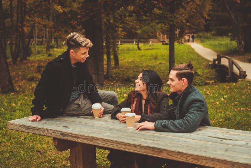 Friends Behind Wooden Table in Autumn Park Stock Photo - Image of park ...