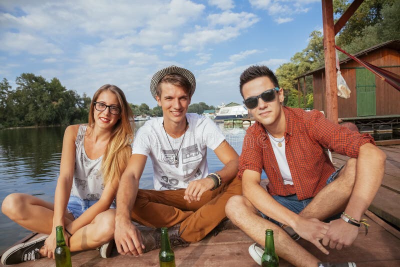 Friends Chilling Near Lake stock image. Image of modern - 78982375