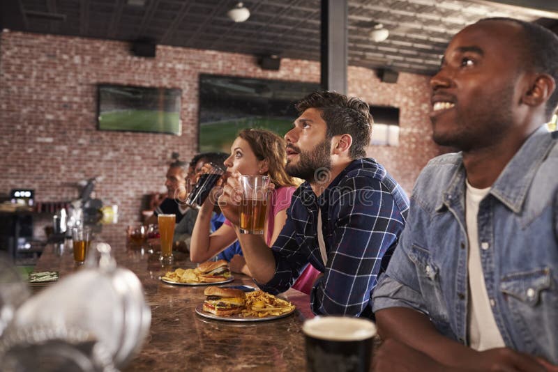 Friends at Counter in Sports Bar Watch Game and Celebrate Stock Image ...